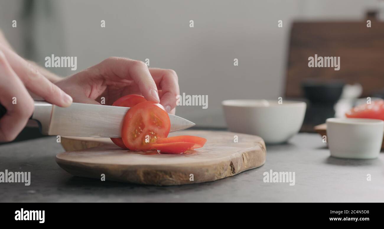 Male hand cutting tomato on hi-res stock photography and images - Alamy