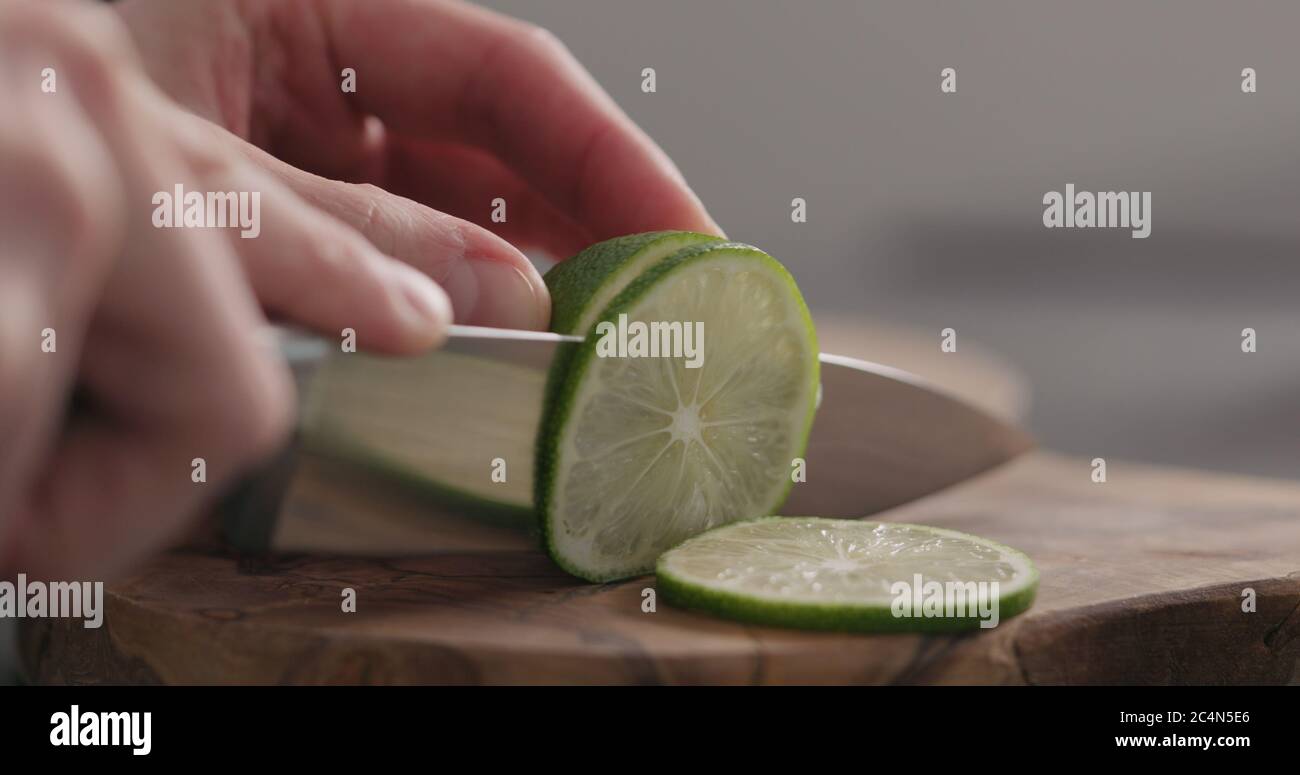 man hands slicing lime with knife Stock Photo - Alamy