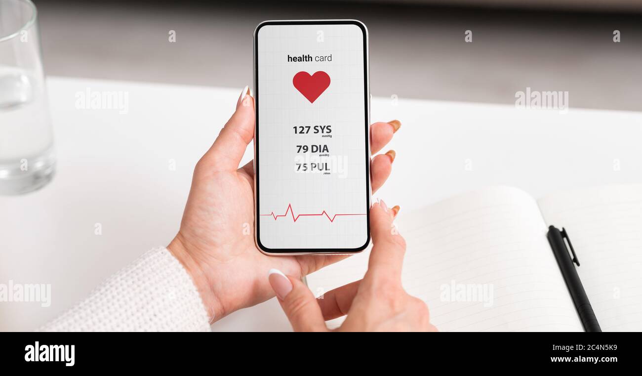 Female hands holding mobile phone with health application showing vital ...