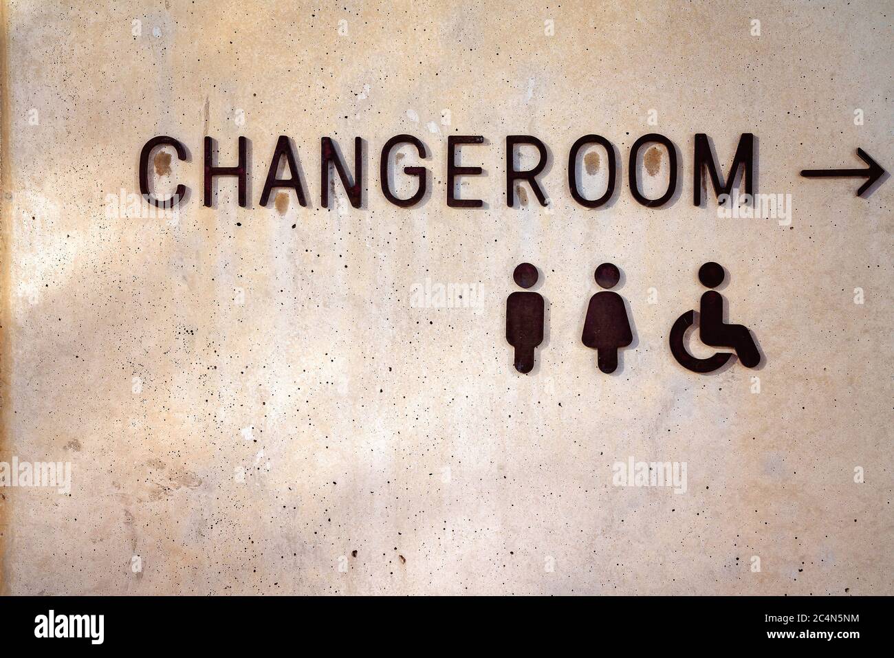 Change Room sign with icons and arrow on a pitted concrete wall Stock ...