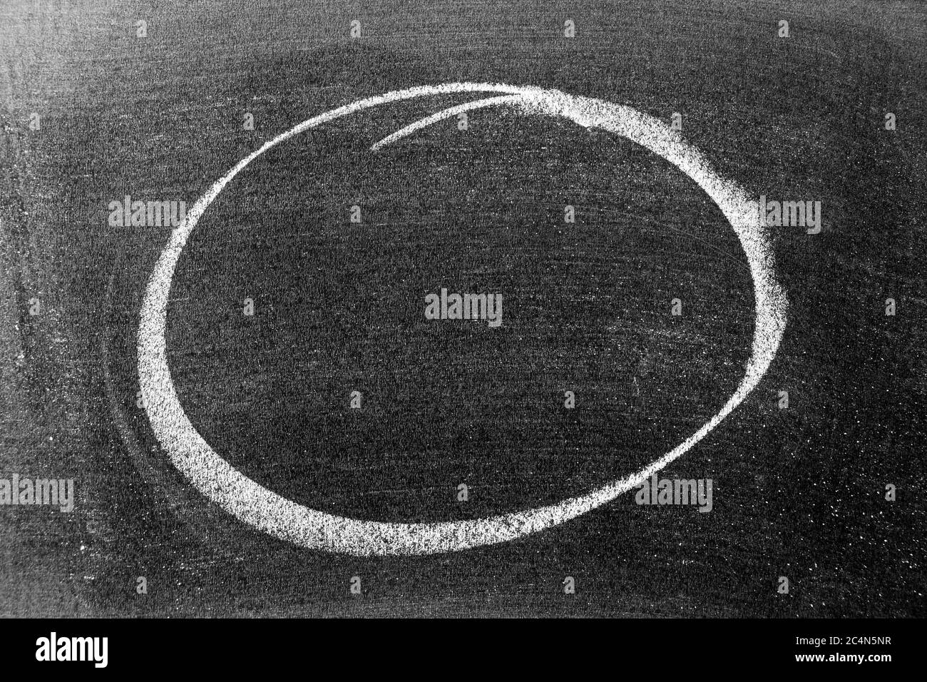 White color chalk hand drawing in circle or oval shape on black board ...