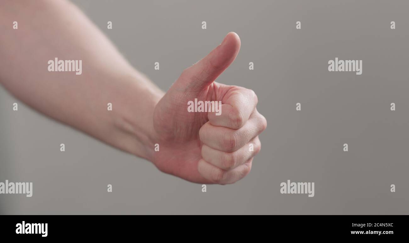 man hand show thumb up over neutral background Stock Photo - Alamy