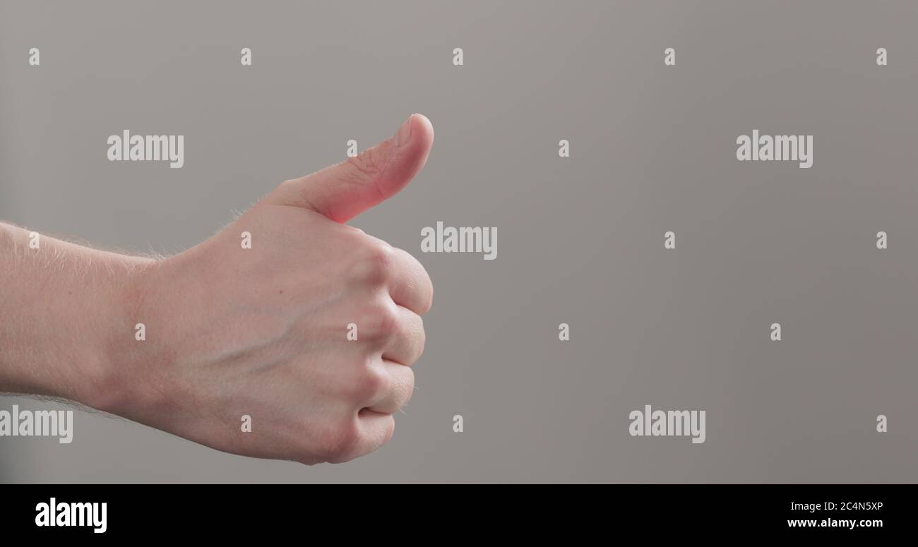 man hand show thumb up over neutral background Stock Photo - Alamy