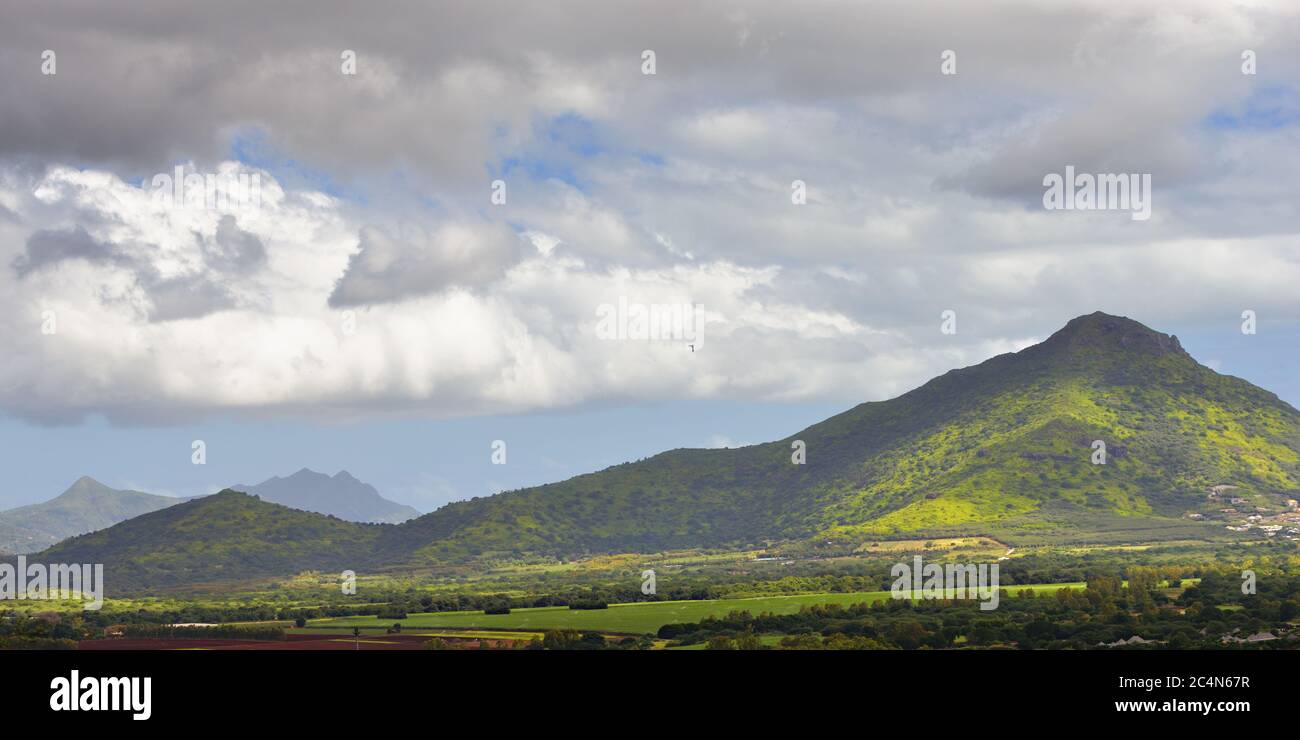 Typical Mauritius landscape, spread fields and high cliff against blue ...