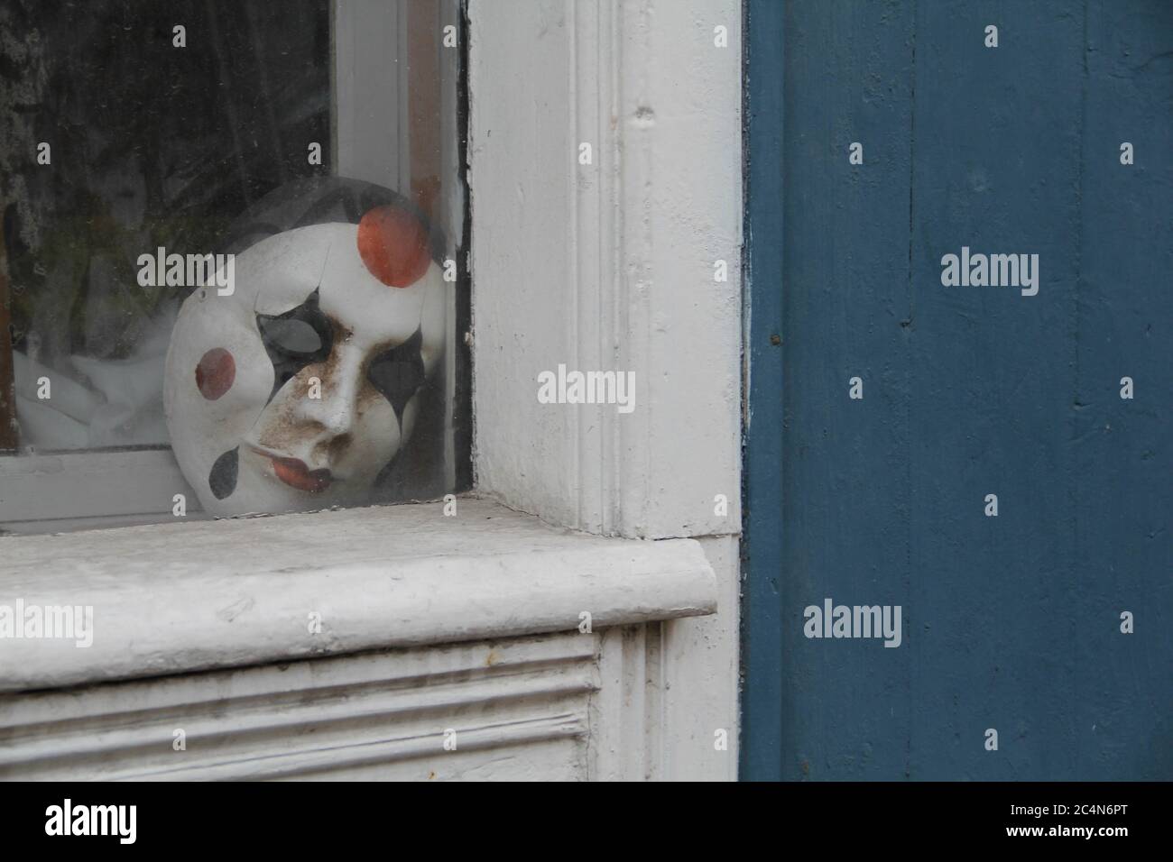 Creepy clown mask near the window Stock Photo - Alamy