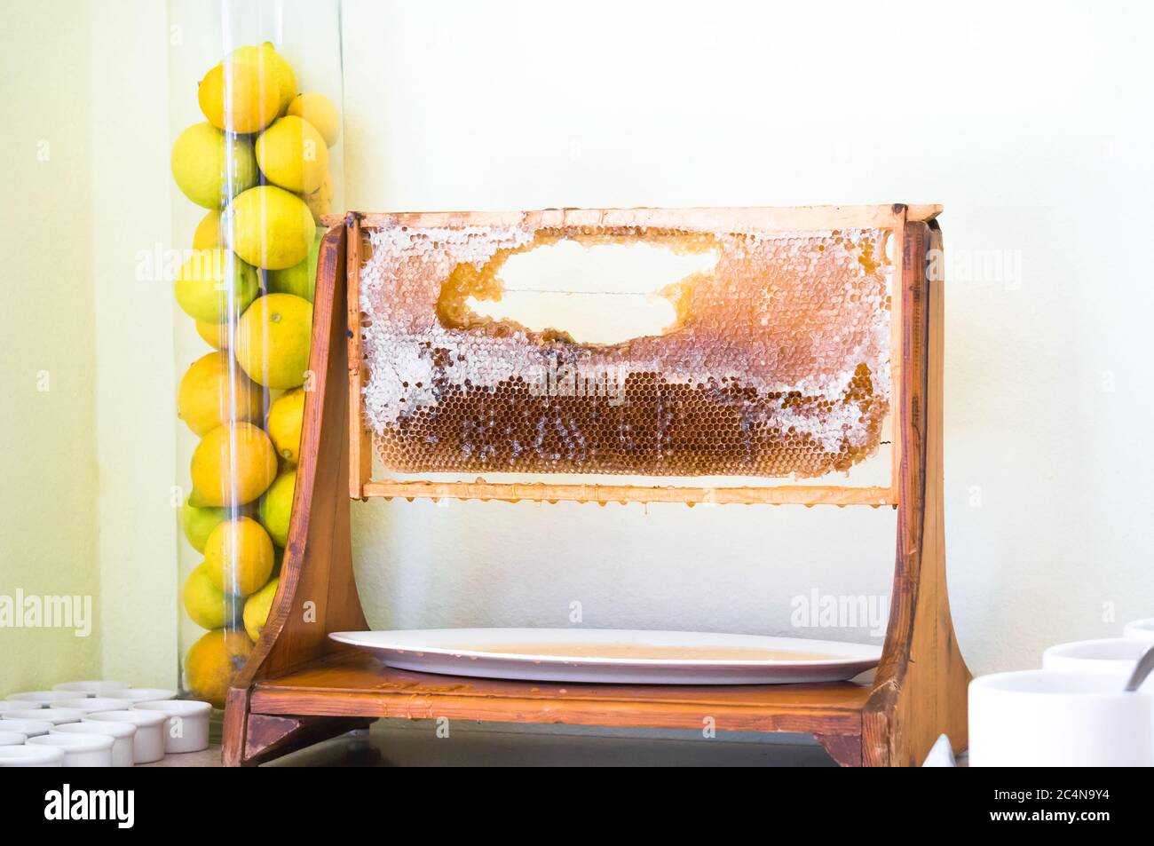 Wooden honeycomb display frame in restaurant and lemons aside in glass ...