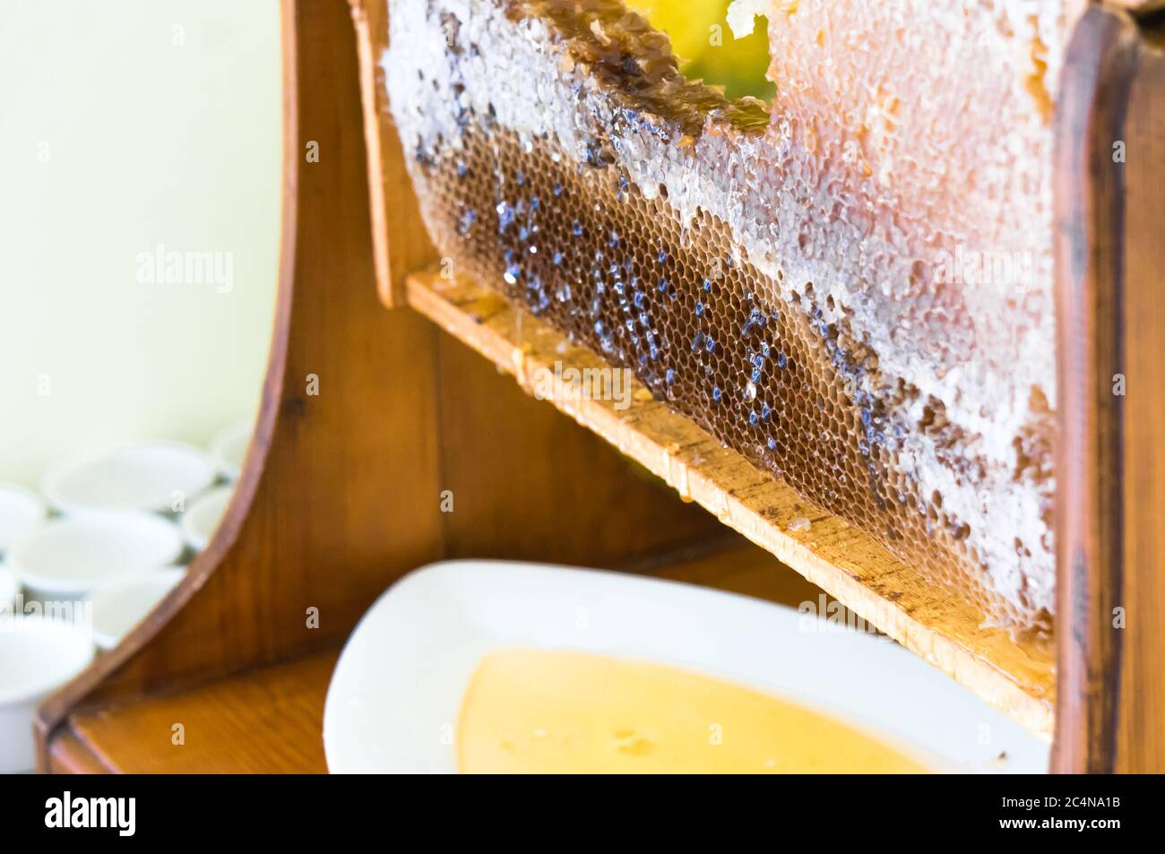 Honeycomb in frame with honey dripping on plate Stock Photo - Alamy