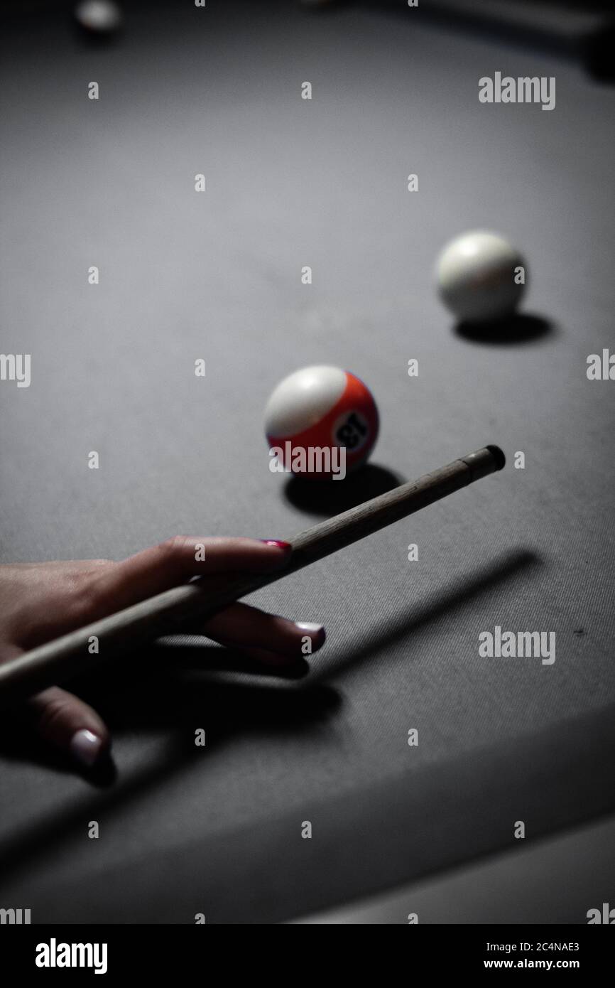 Female holding a stick and playing billiard Stock Photo - Alamy