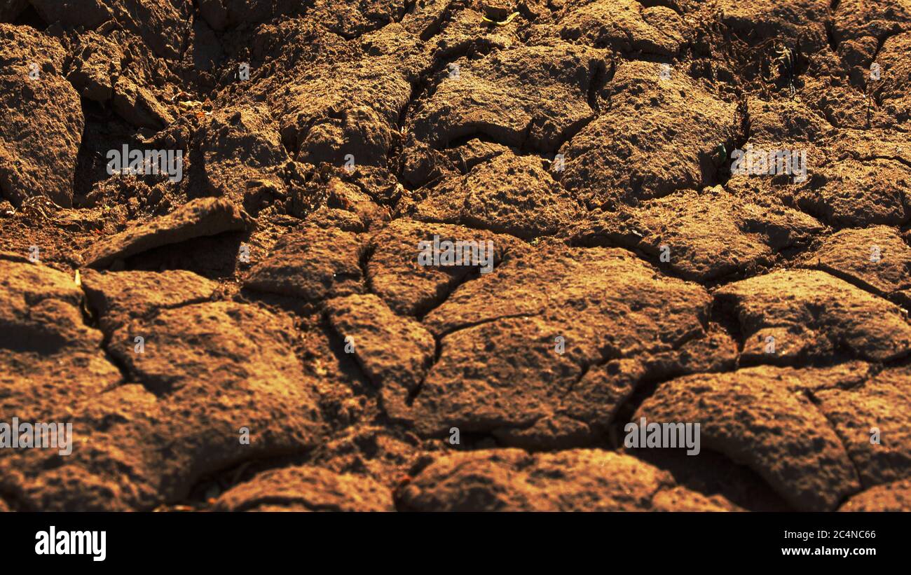 drought background texture of cracked earth soil orange color closeup ...