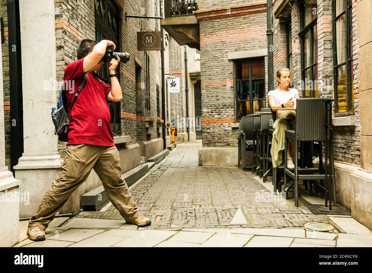 A Chinese photographer taking pictures of a Western female model in the ...