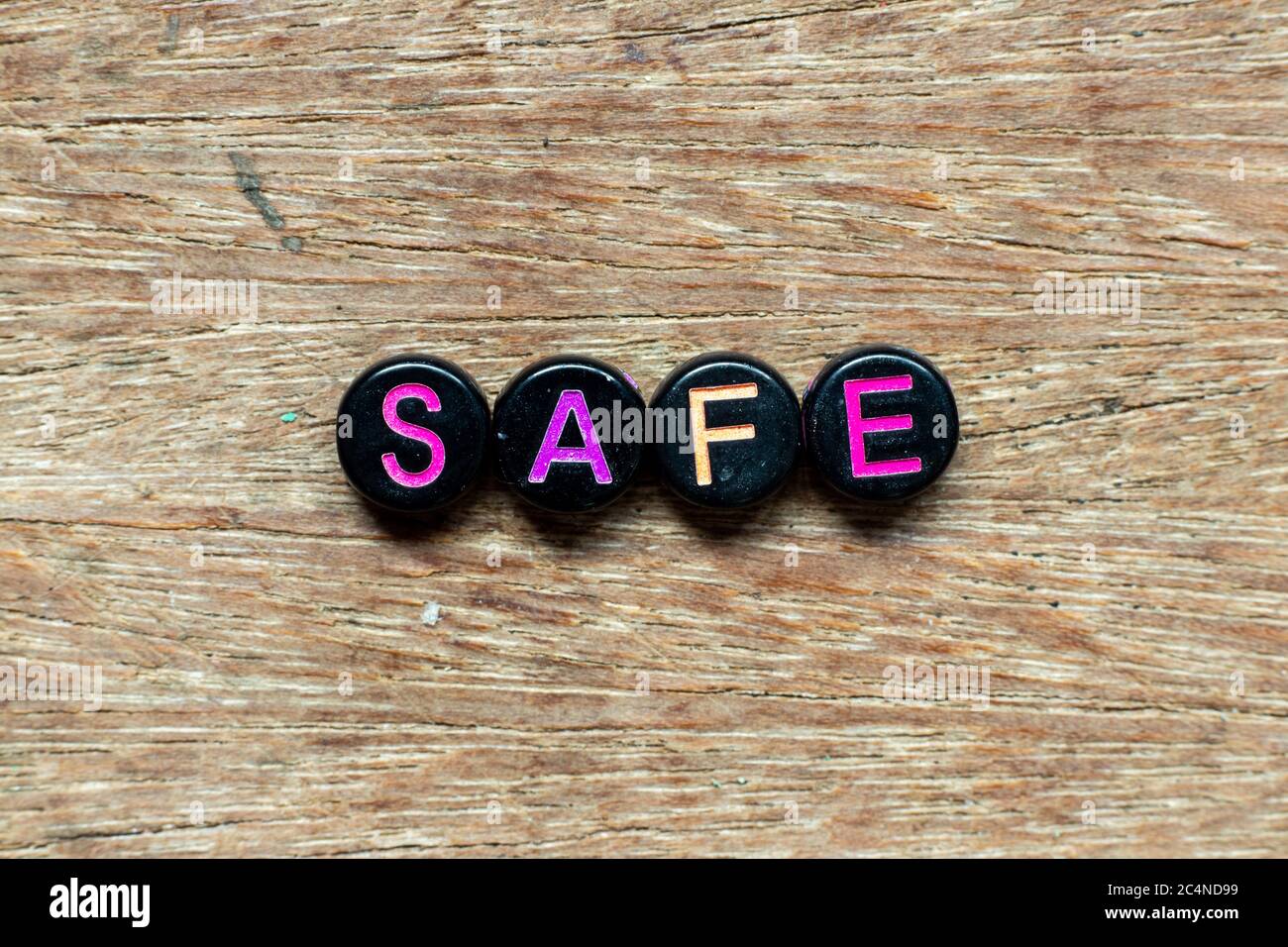 Black bead with color letter in word safe on wood background Stock ...
