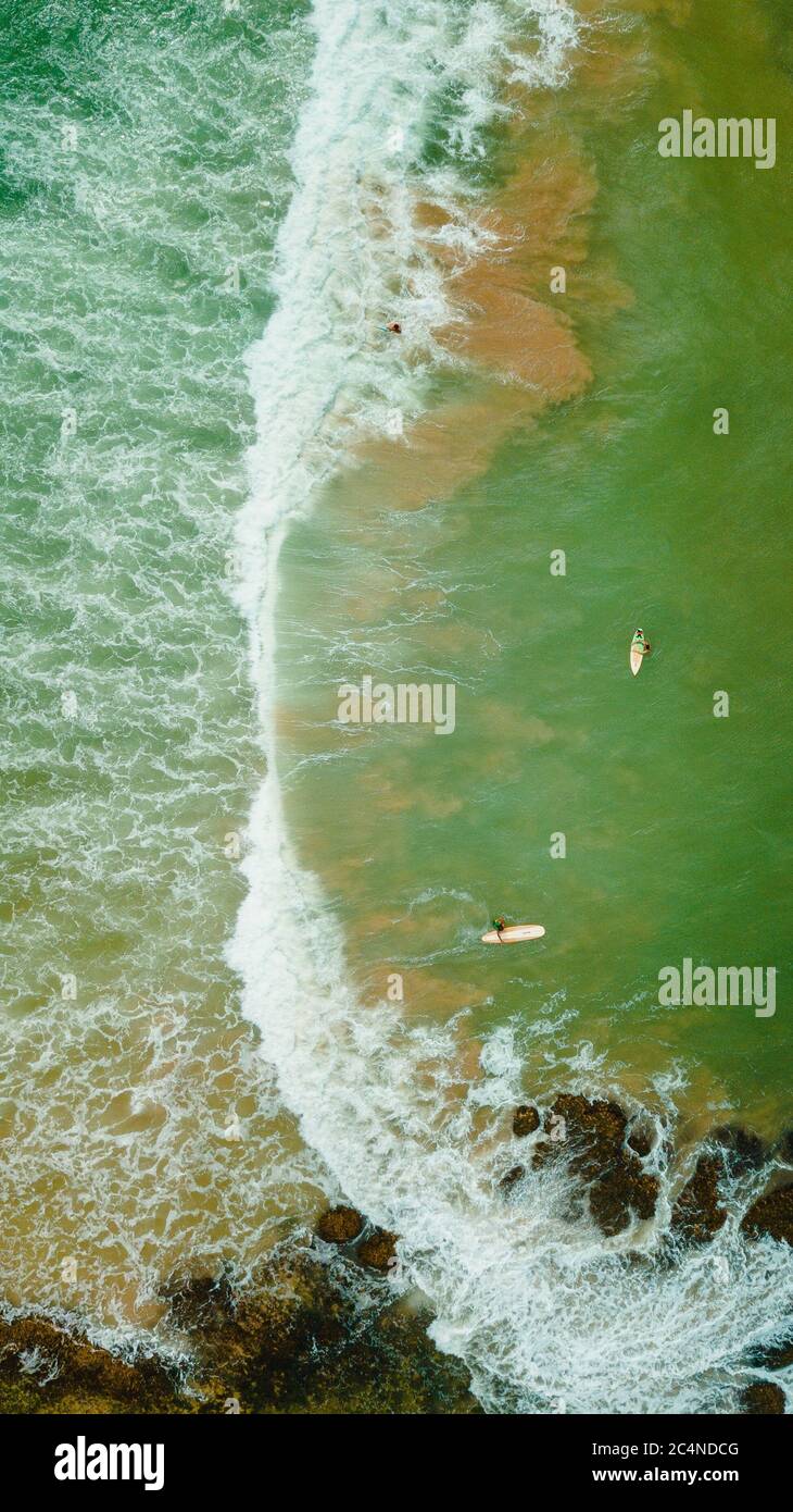 Aerial breathtaking shot of the surfers surfing on the ocean wave Stock ...