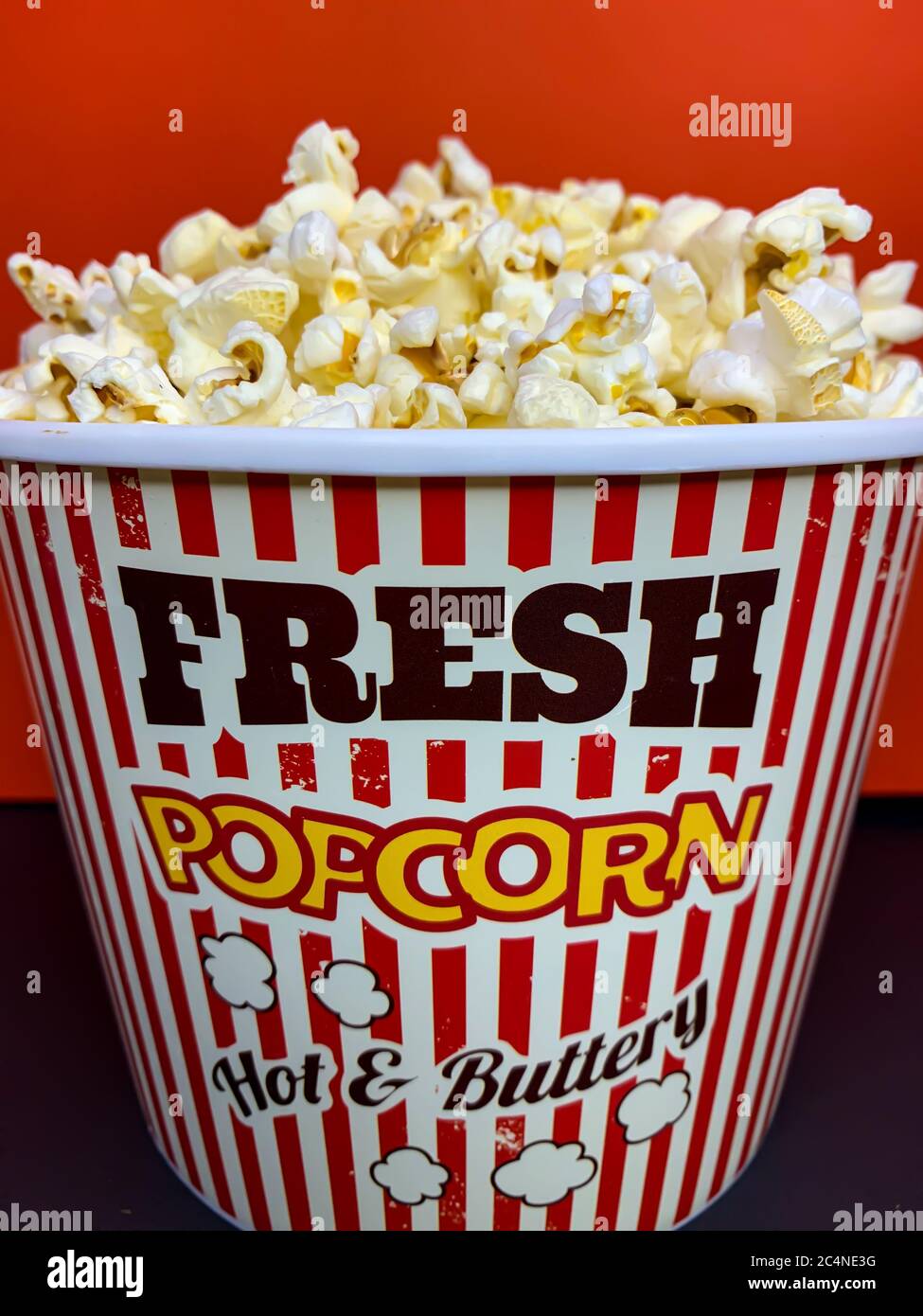 Close up delicious fresh buttery popcorn in a stripped red and white ...