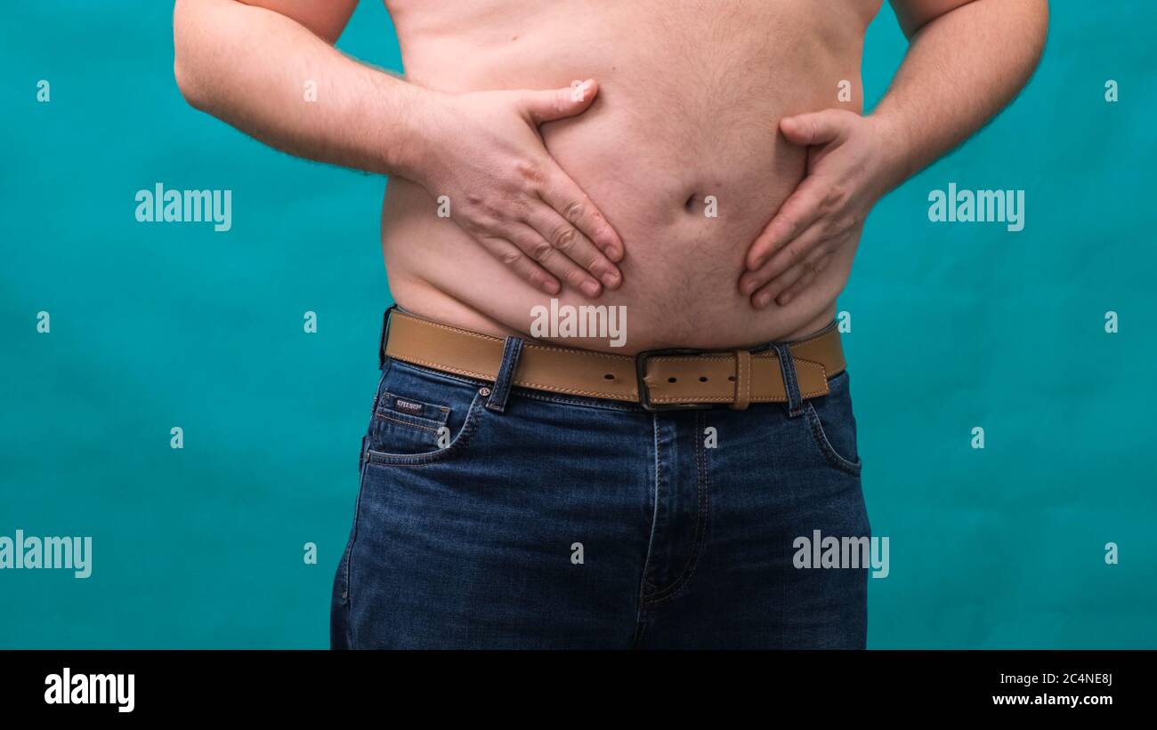 male with a big belly shows his fat on a green screen. The concept of ...