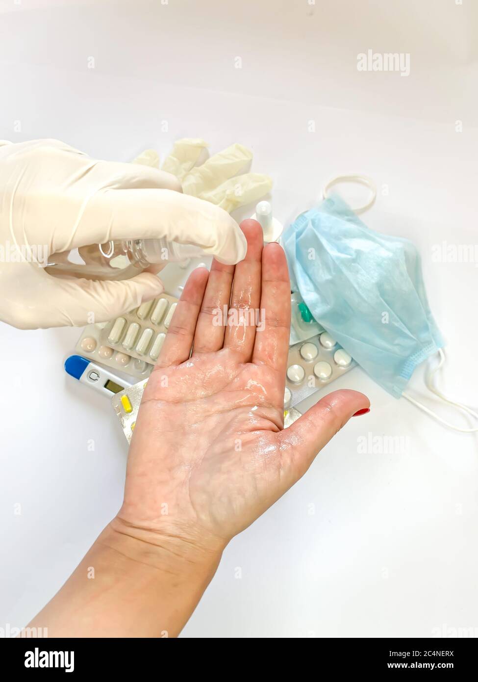 Hand of female in medical glove that applying alcohol spray or anti ...