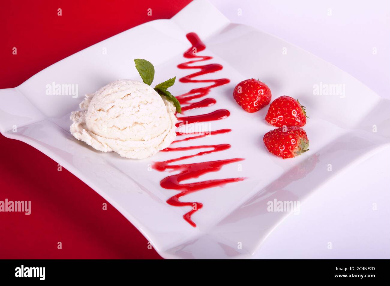 Fancy dessert with vanilla ice cream, strawberries and raspberry sauce ...