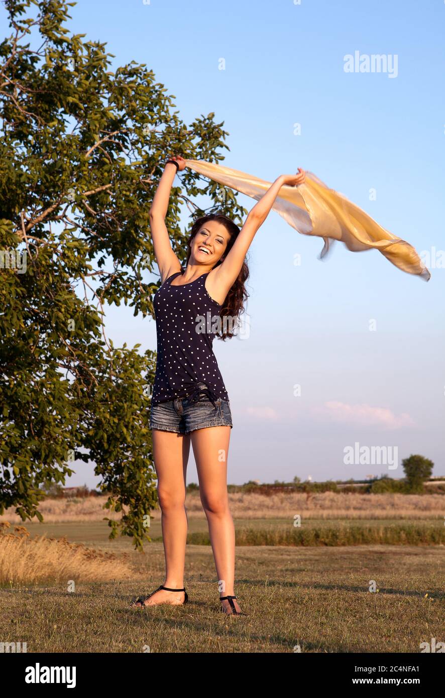 Happy woman waving her scarf in the wind Stock Photo - Alamy