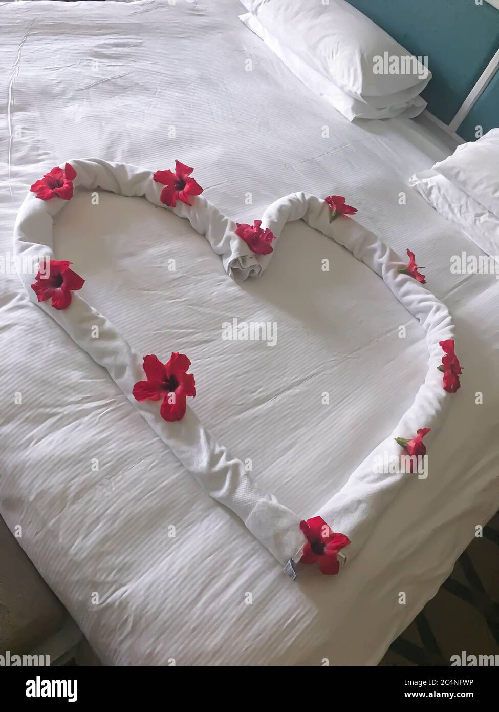 Heart with flowers decor on a bed in hotel room Stock Photo - Alamy