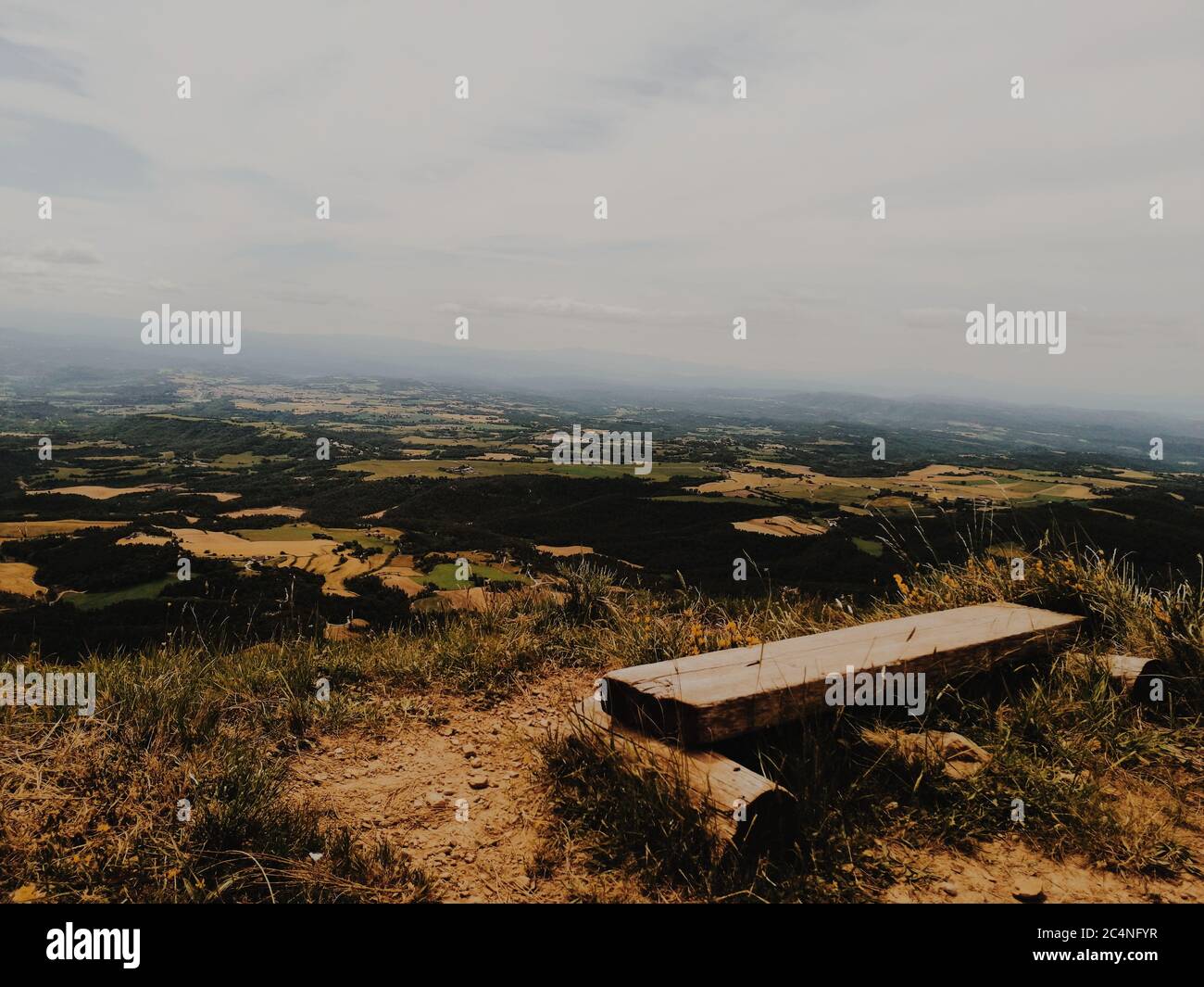 Mountain summit with a wooden bench and a beautiful view of green ...