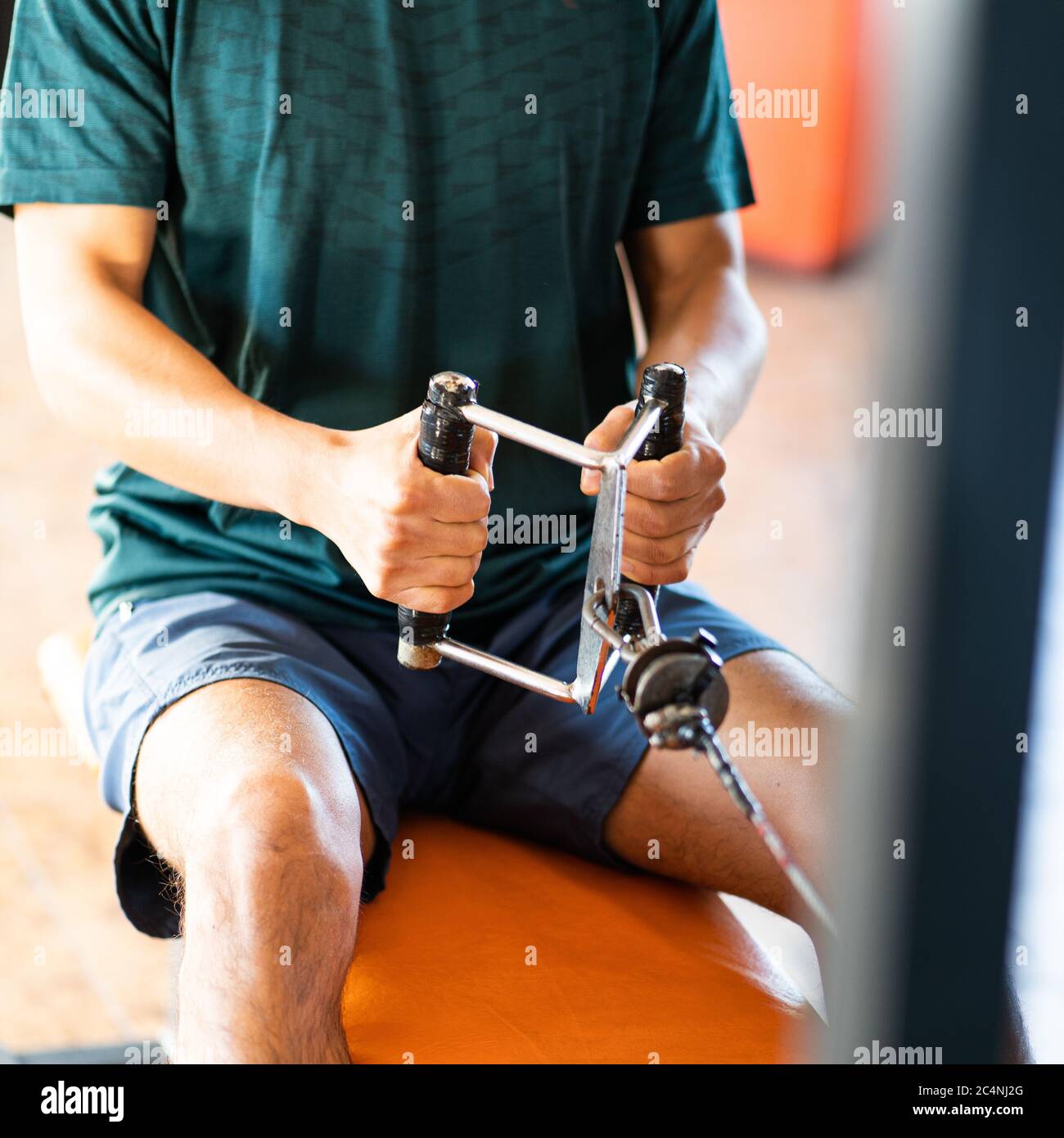 Closeup of a person doing exercises on a rowing machine under the ...