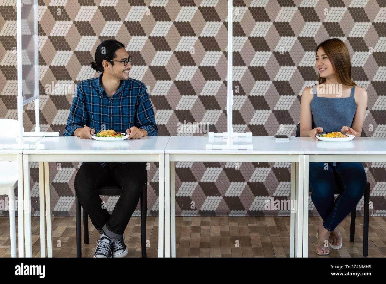Asian young couple eating out together at new normal social distance ...