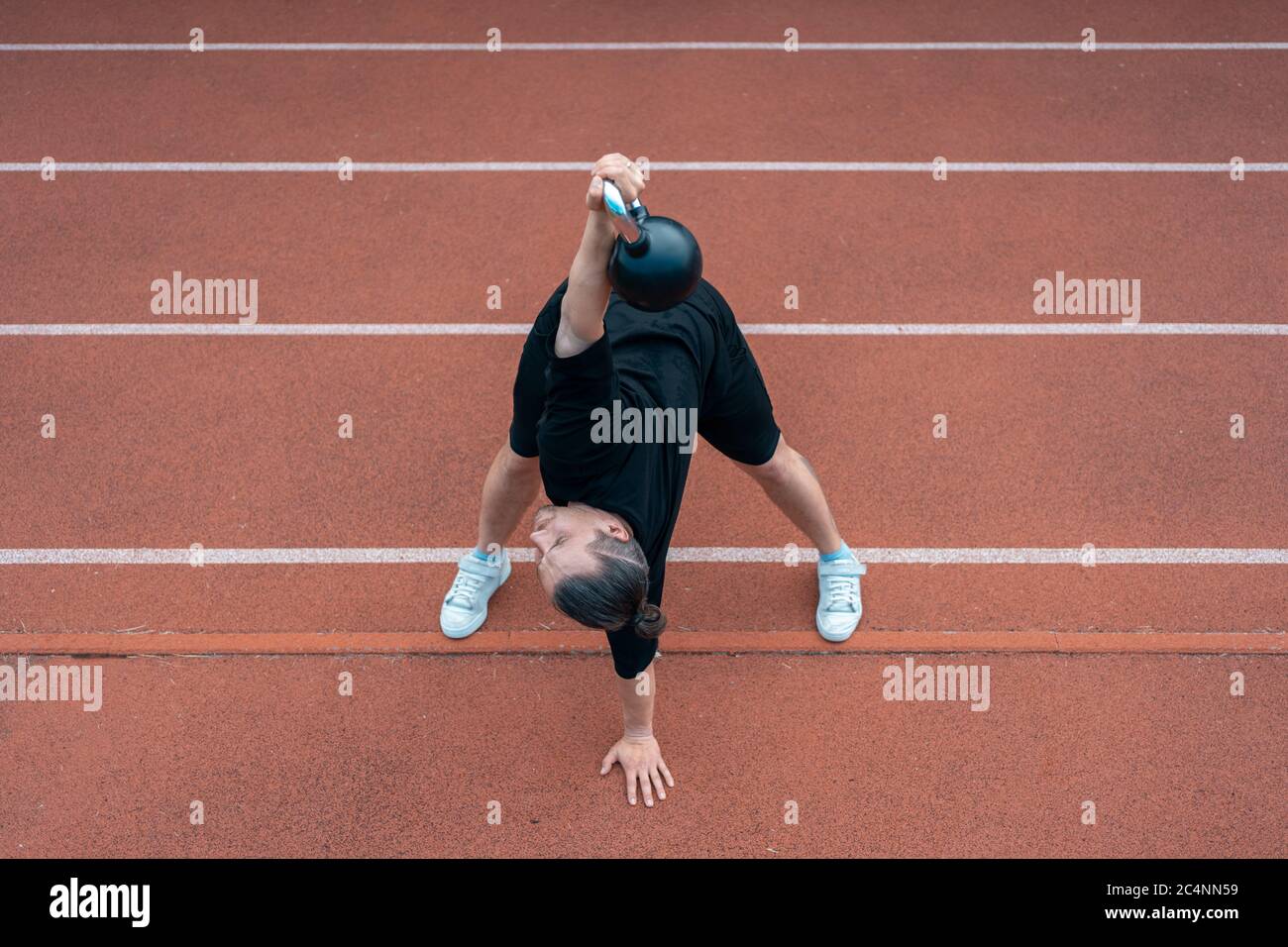 young athlete has workout and doing sport exercises with kettlebell ...