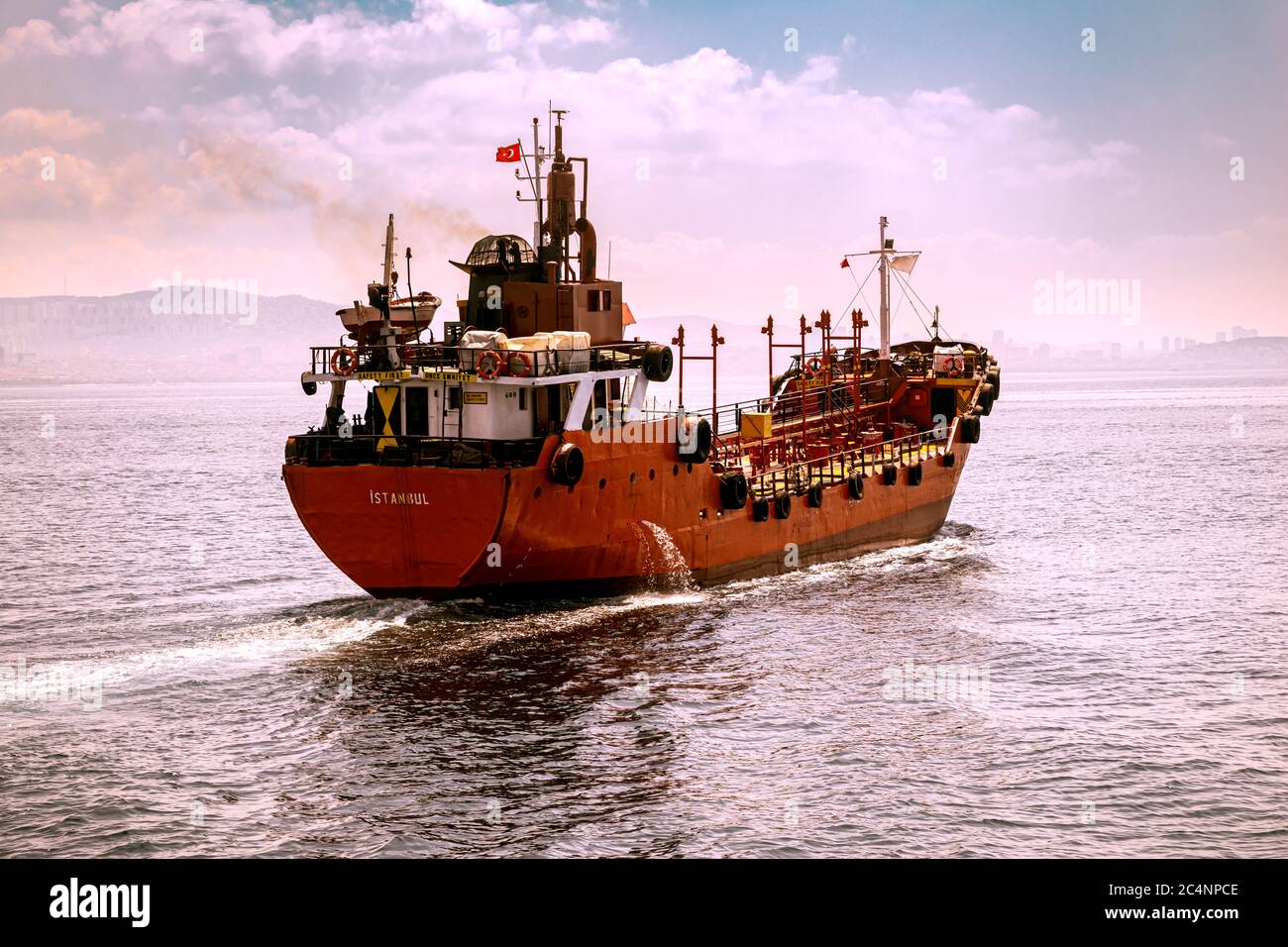 a very large red ship sails on the sea, from behind angle Stock Photo ...