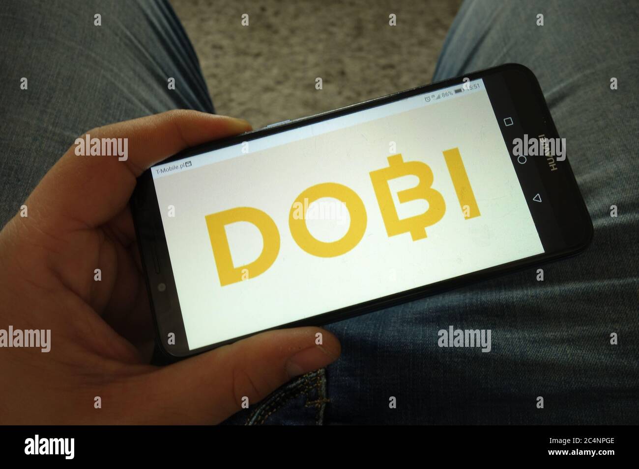Man holding smartphone with Dobi cryptocurrency exchange logo Stock ...