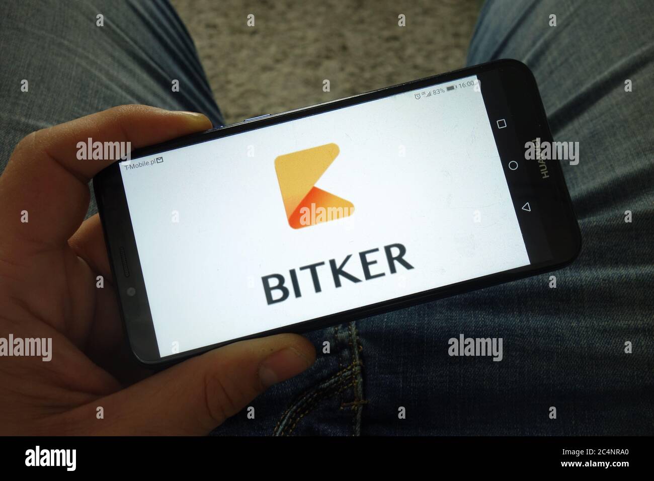 Man holding smartphone with Bitker cryptocurrency exchange logo Stock ...