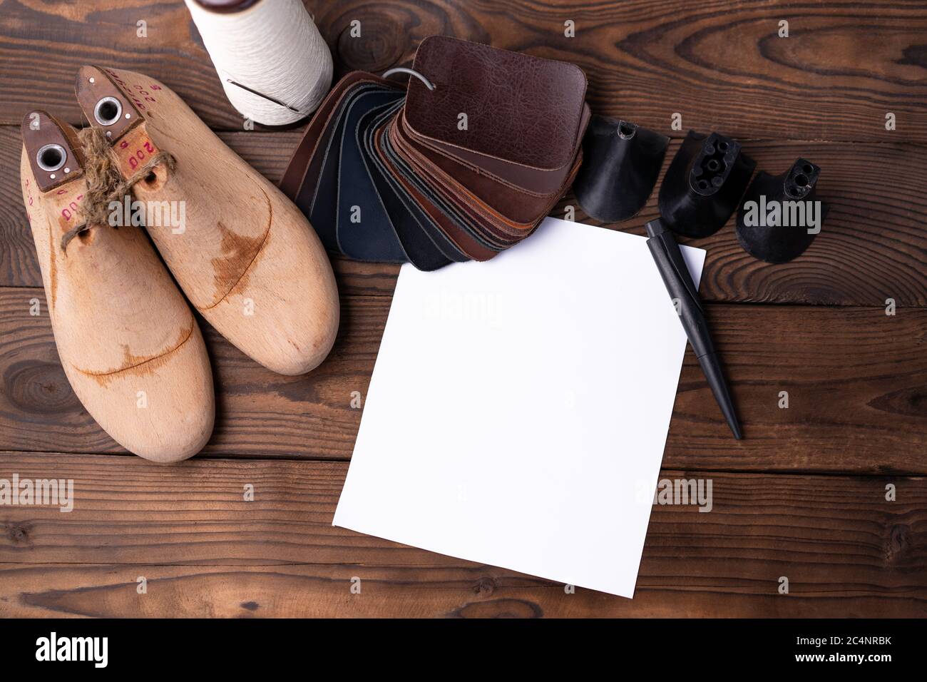 Leather samples for shoes and wooden shoe last on dark wooden table ...
