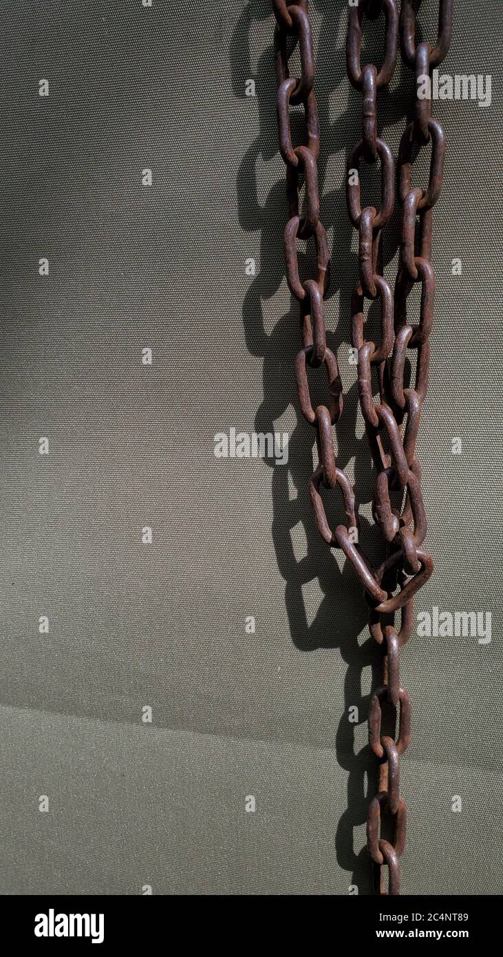 Bunch of old rusty metal chains on rough tarpaulin background with copy ...