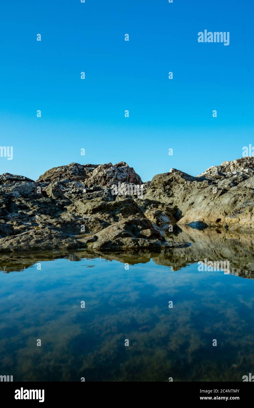 the rocks on the beach on a beautiful summer day and the sky is blue ...