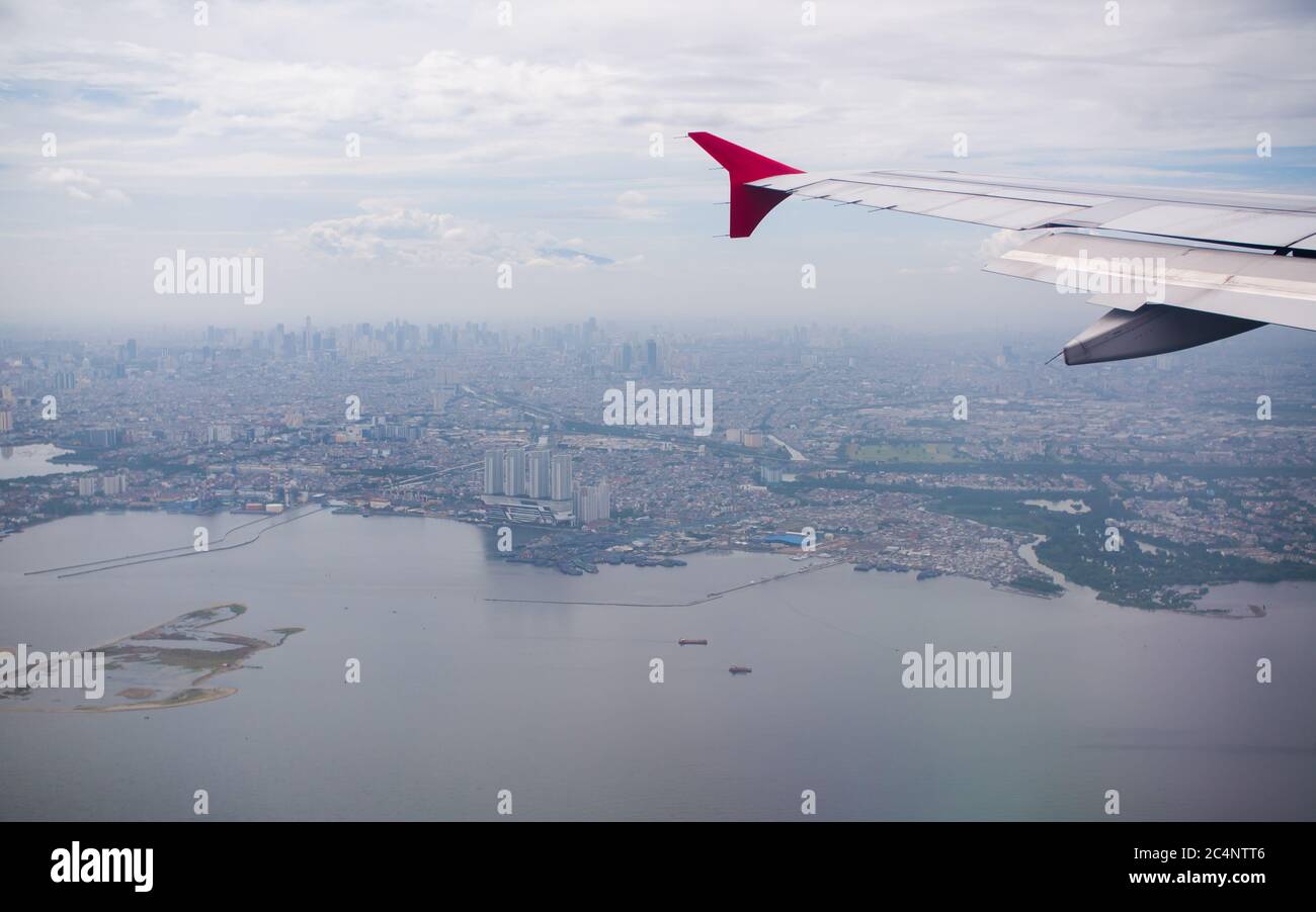 The plane flies against the background of the city of Jakarta ...