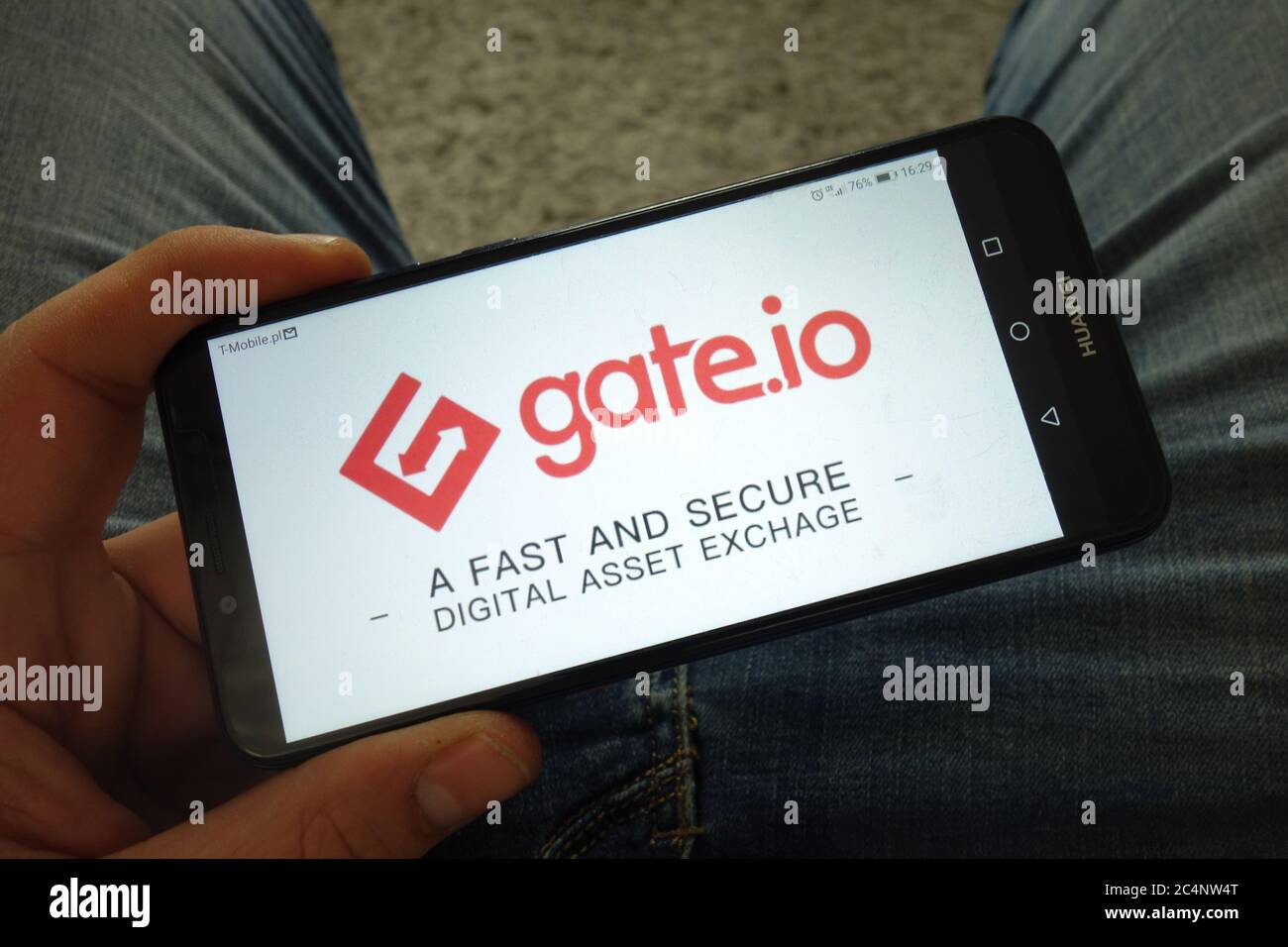 Man holding smartphone with Gate.io cryptocurrency exchange logo Stock ...