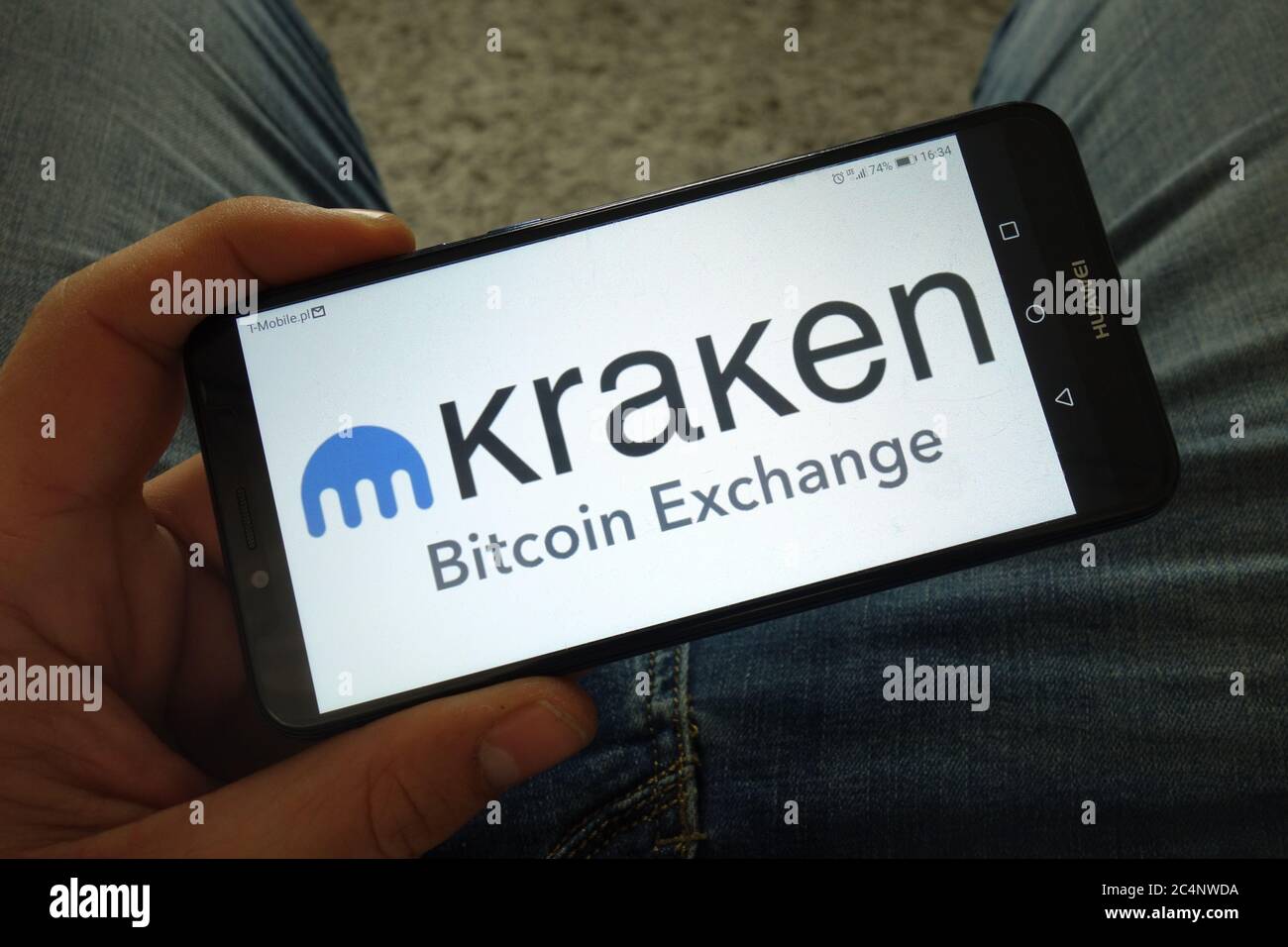 Man holding smartphone with Kraken cryptocurrency exchange logo Stock Photo - Alamy