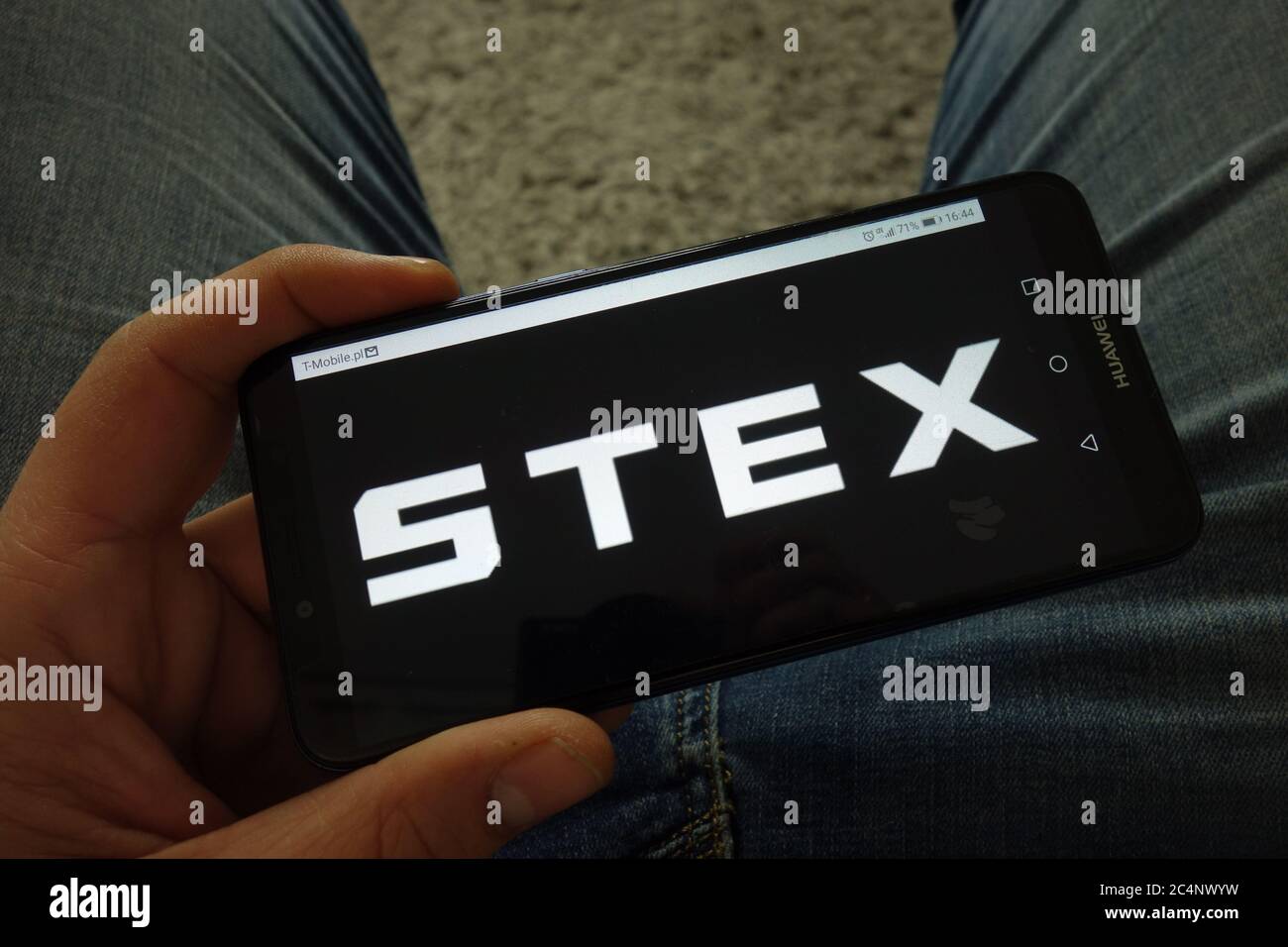 Man holding smartphone with STEX cryptocurrency exchange logo Stock Photo - Alamy