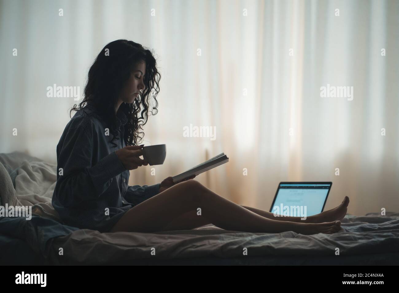 pretty brunette woman in morning bed with books and coffee Stock Photo ...
