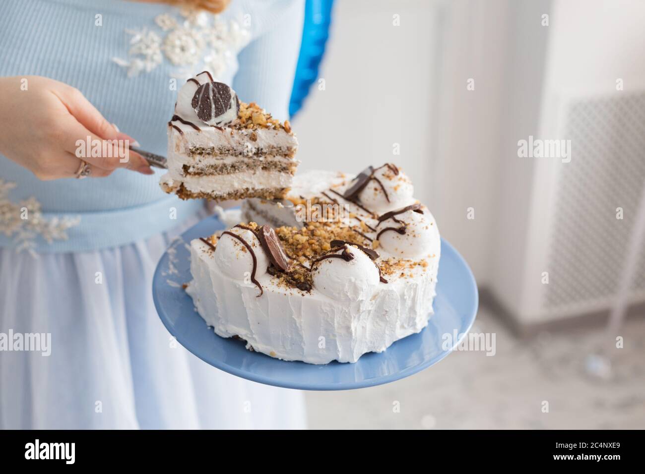 girl with a birthday cake. finger in the cream on the cake. cake on a ...