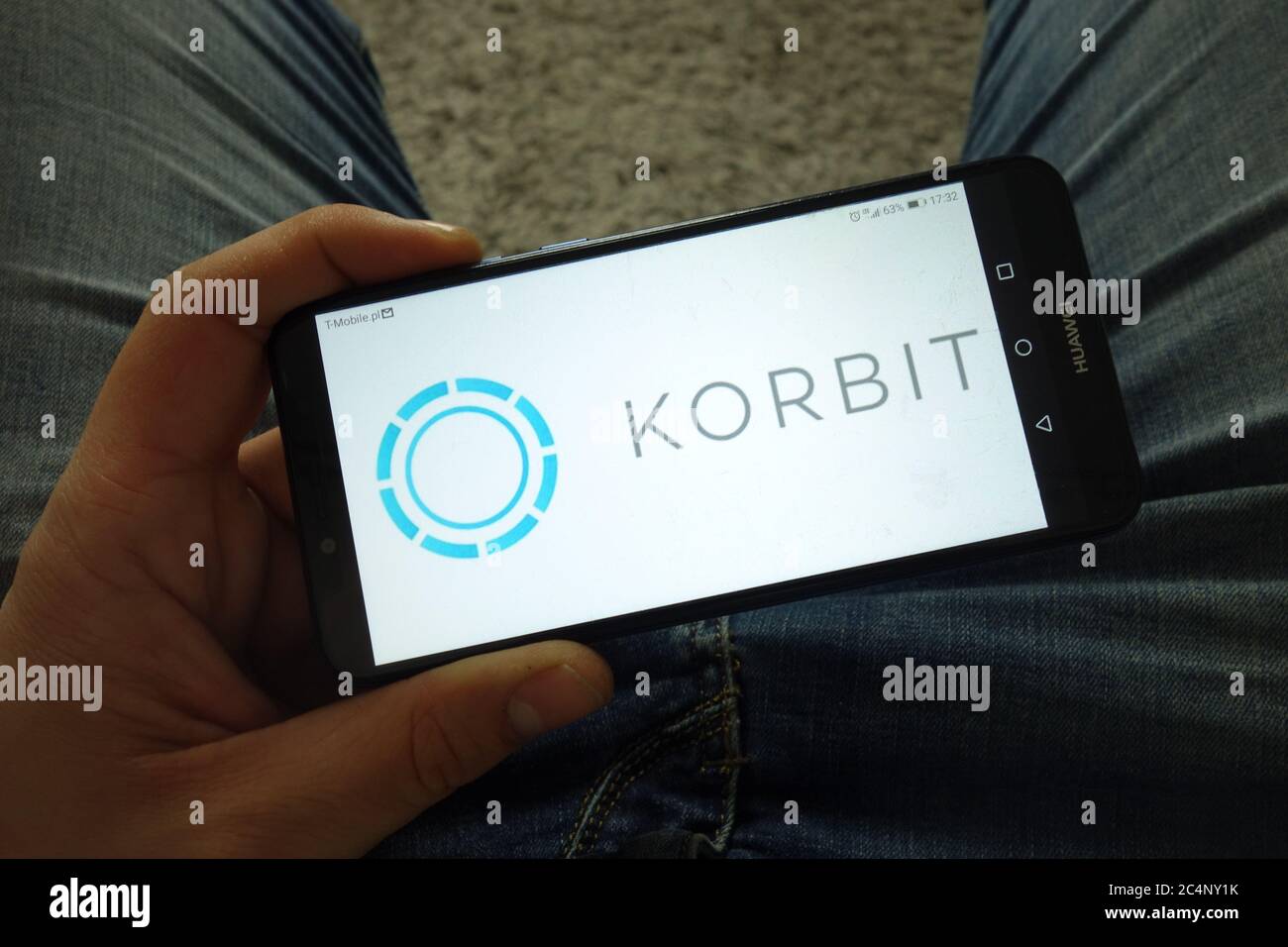 Man holding smartphone with Korbit cryptocurrency exchange logo Stock Photo - Alamy