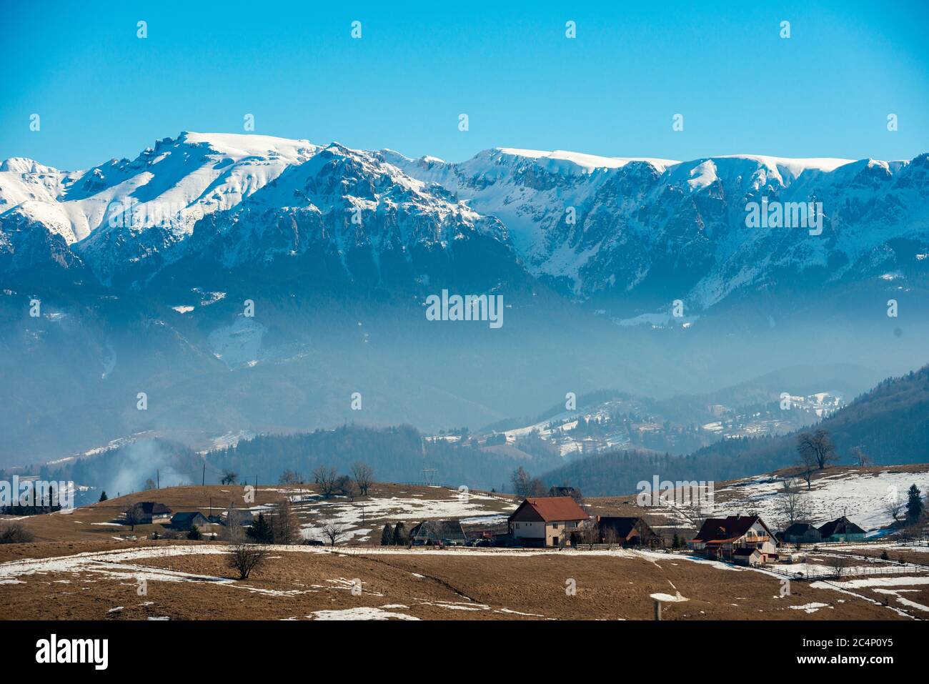 rocky mountains full of snow and villages in the valley Stock Photo - Alamy