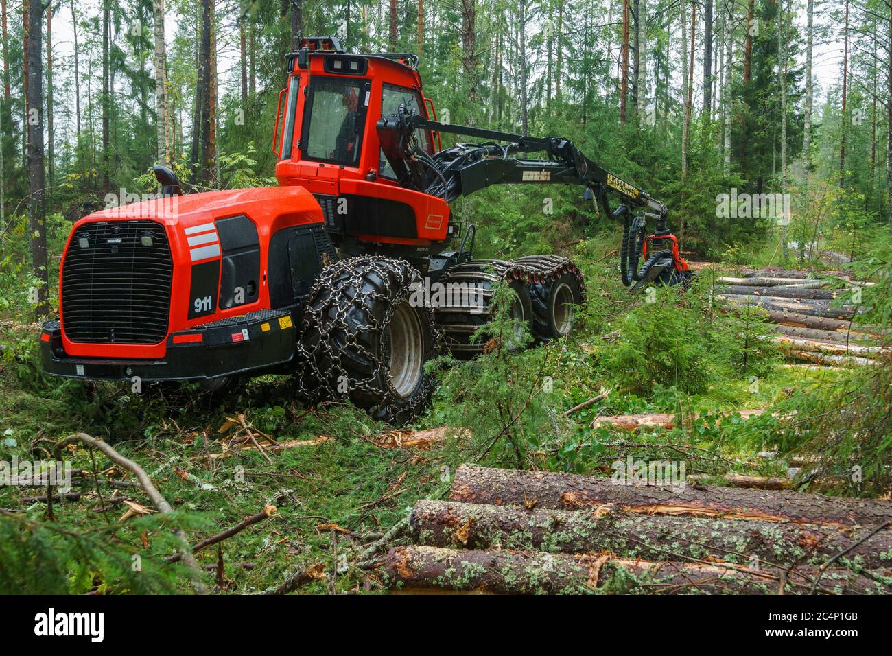 Red Komatsu 911 forest harvester at logging site with cut and piled ...