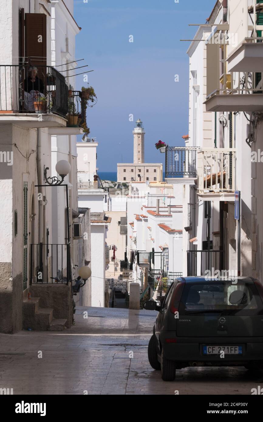 Sunny street with parked car in Vieste in Italy with the lighthouse in ...