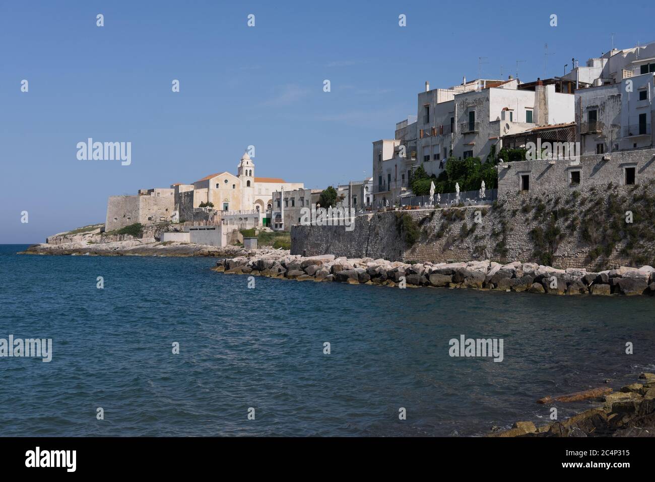 View of the coast with white houses and wall around Vieste in Puglia ...