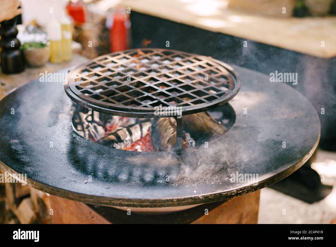Round grill with flat roasting. Round grille in the center with a fire ...