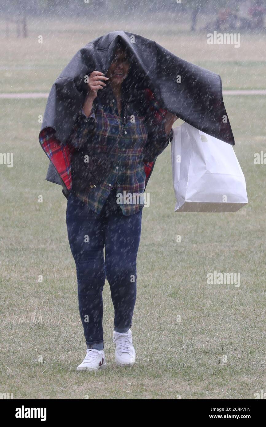 People take cover from the rain in London's Hyde Park, as rain, wind ...