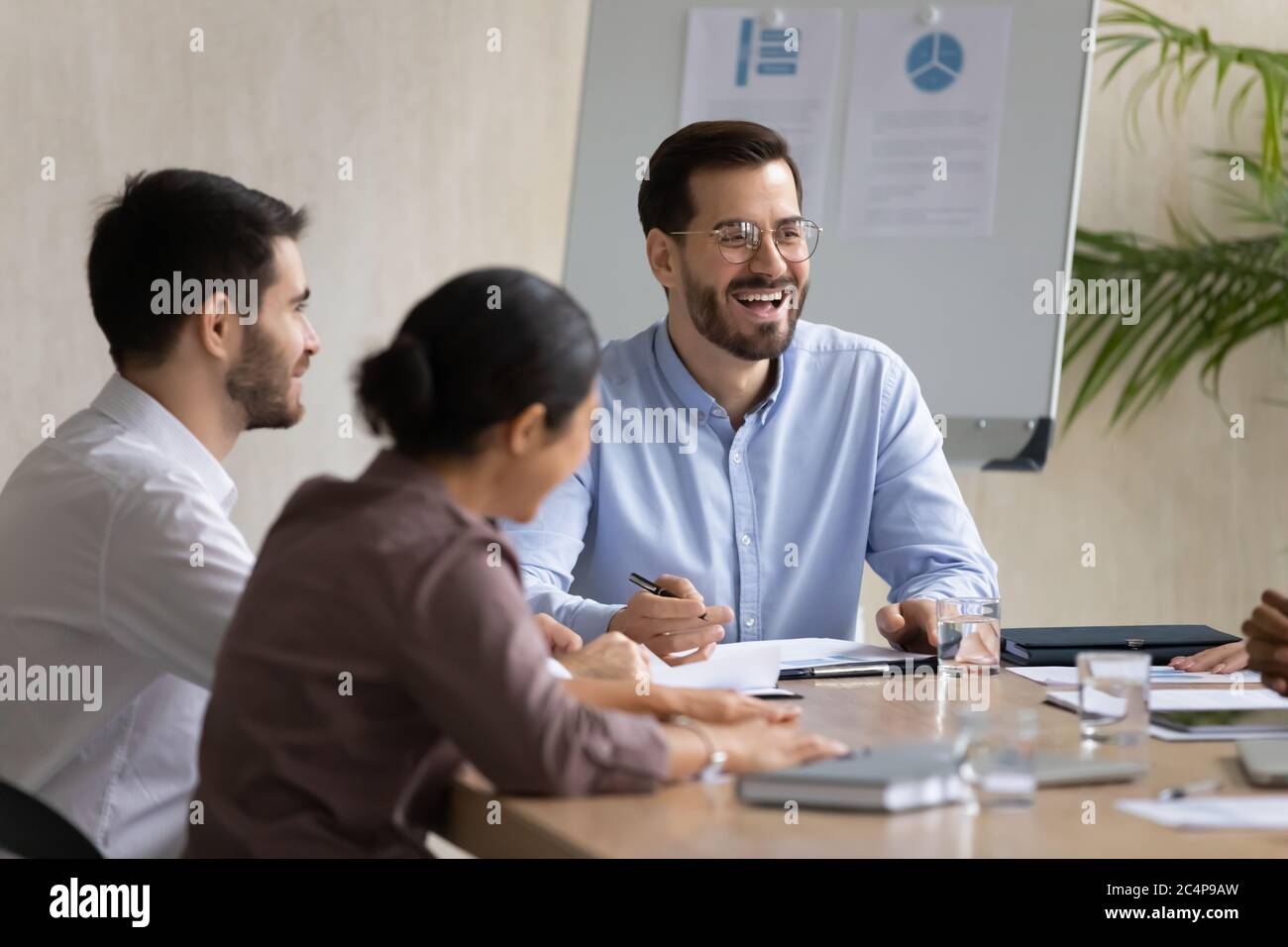 Happy diverse employees with team leader having fun at briefing Stock ...