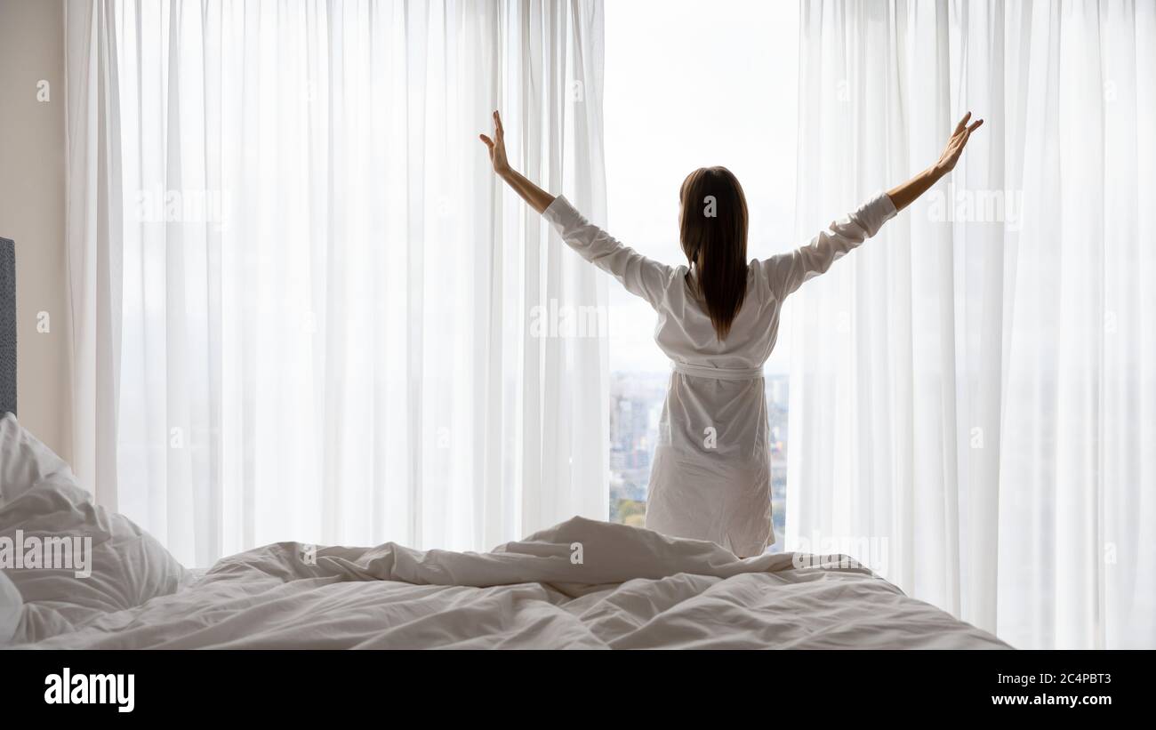 Happy young woman stretch in bed welcoming new day Stock Photo - Alamy