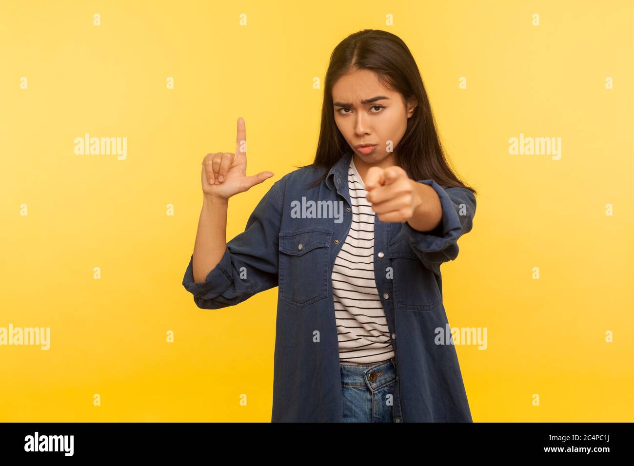 Hey you loser! Portrait of girl in denim shirt making, L sign and ...