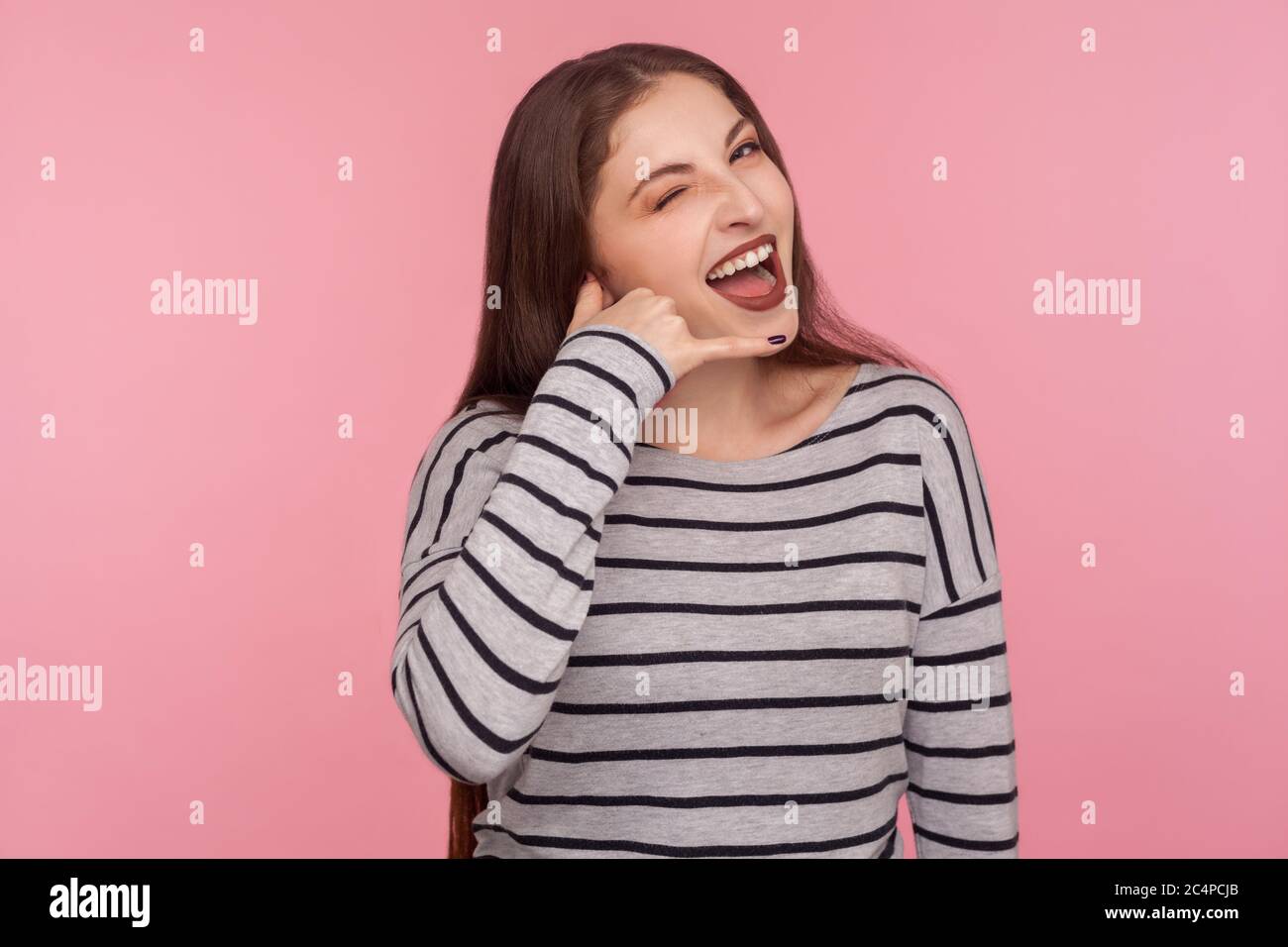 Call me! Portrait of beautiful happy flirtatious woman in striped ...