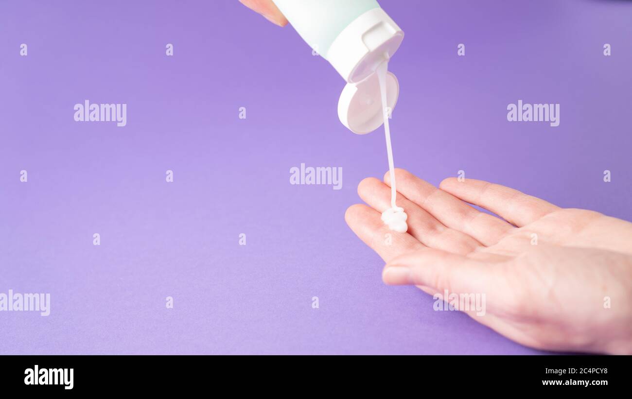 Hand cream. Pouring lotion from tube on hand. Body cream drop on hand ...